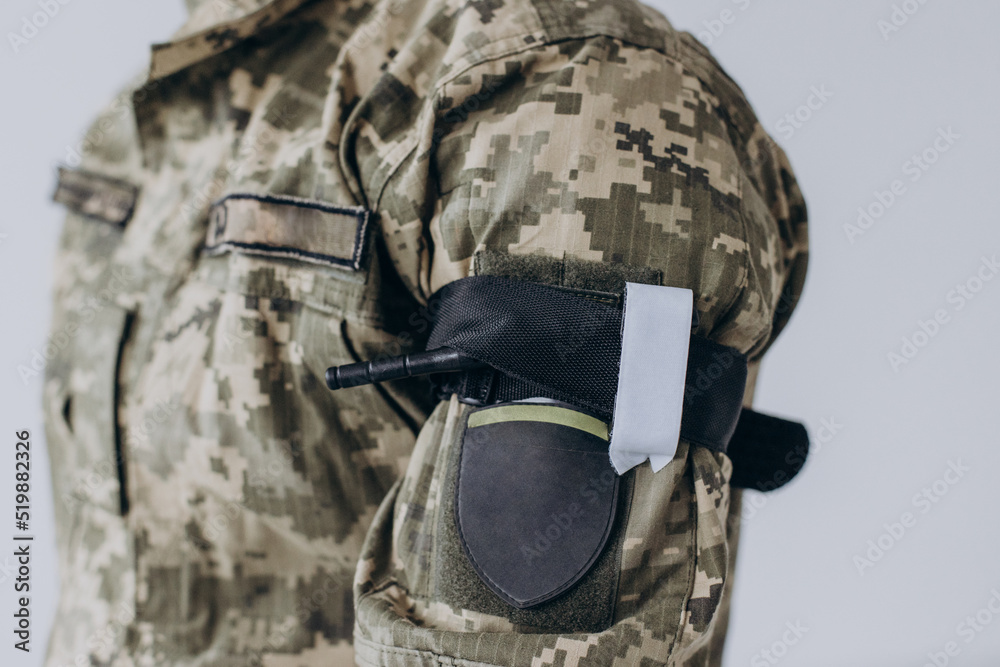 A military man demonstrates a combat medical tourniquet to stop blood ...