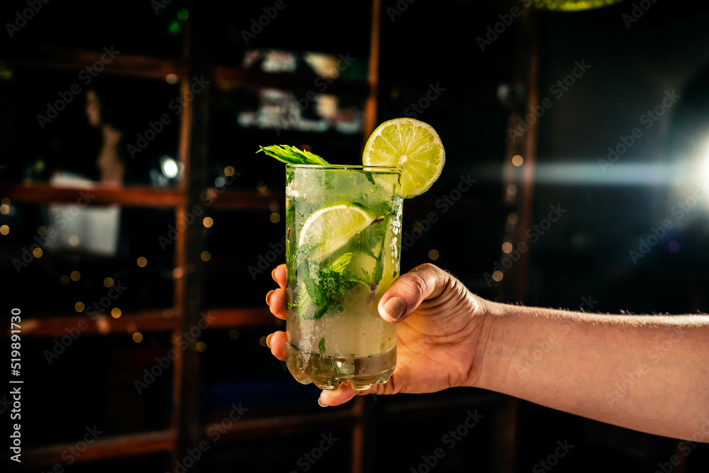 coctel de mojito sostenido en mano Stock-Foto | Adobe Stock