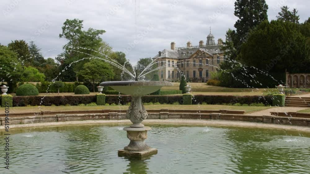 A water fountain in a large pool in the luxurious gardens of a wealthy ...