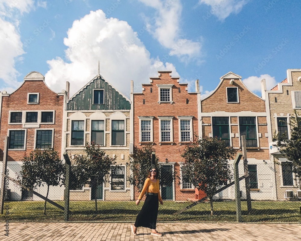 Mulher em frente Casas com estilo holandês no local conhecido como ...