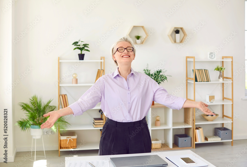 Fotografia do Stock: Happy senior business lady stretching her arms in ...