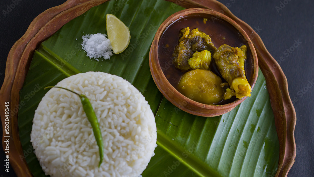 Kolkata style mutton curry and steamed white rice served on a clay ...
