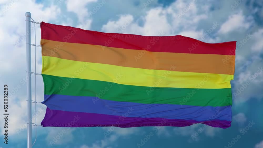 Rainbow LGBT flag waving against a blue sky. LGBT pride flags for gays ...