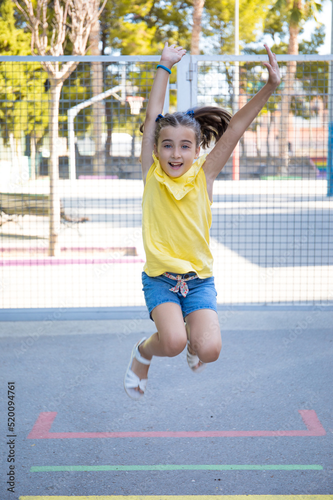Girl jumping up and down with a happy face and her arms in the air ...