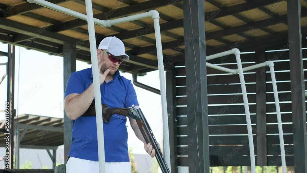 Sportsman shoots from a double-barreled shotgun, A sports field for a ...