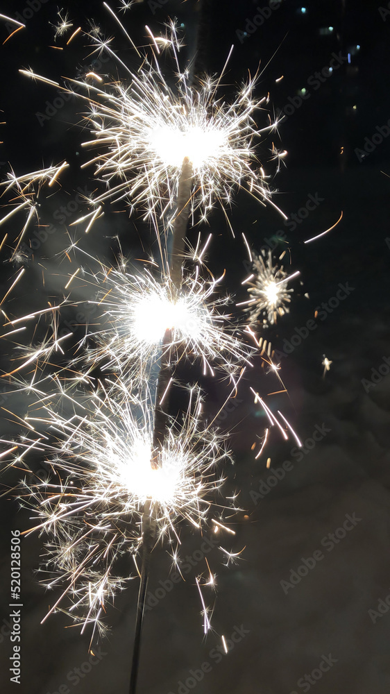 Triple burning sparkler. Sparks fly in different directions..Triple ...