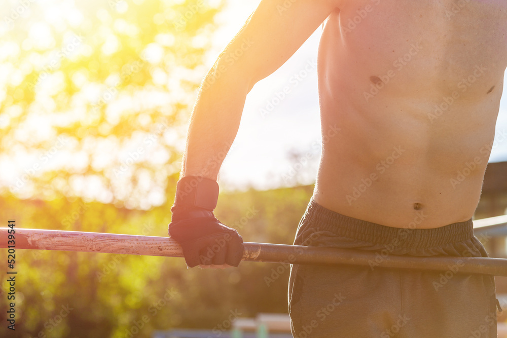 Muscular man during outdoor workout, close up. Strong man in gloves ...