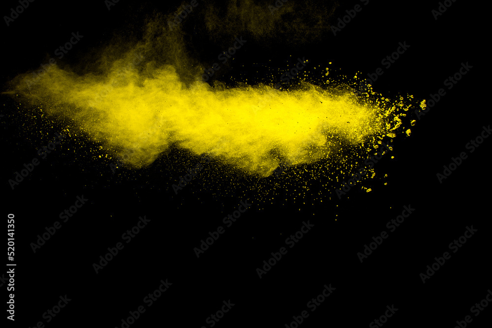 Yellow dust particles explosion on black background.Yellow powder ...