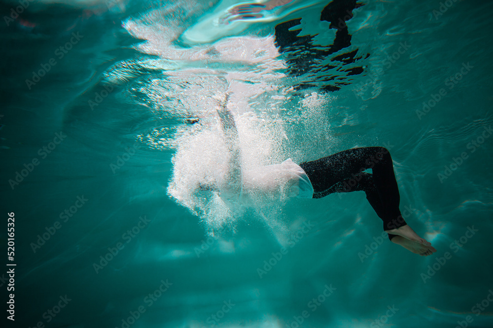 Beautiful underwater shooting, guy in white shirt and pants has fallen ...