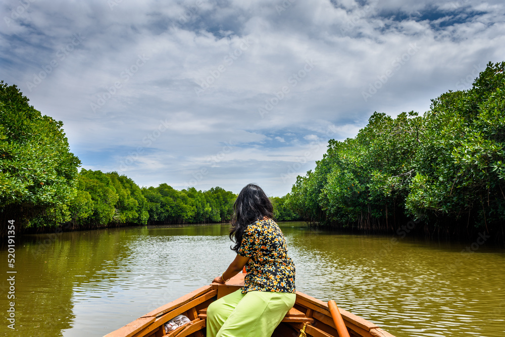 Young Indian woman boating through Pichavaram Mangrove Forests. The ...