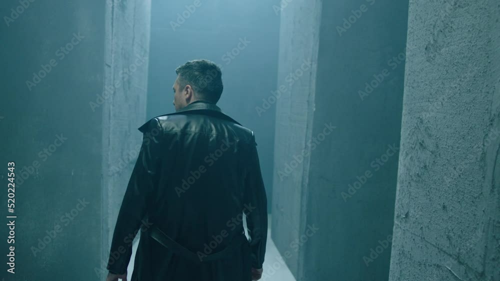 Rear back view of unknown man walking , standing or running inside dark ...