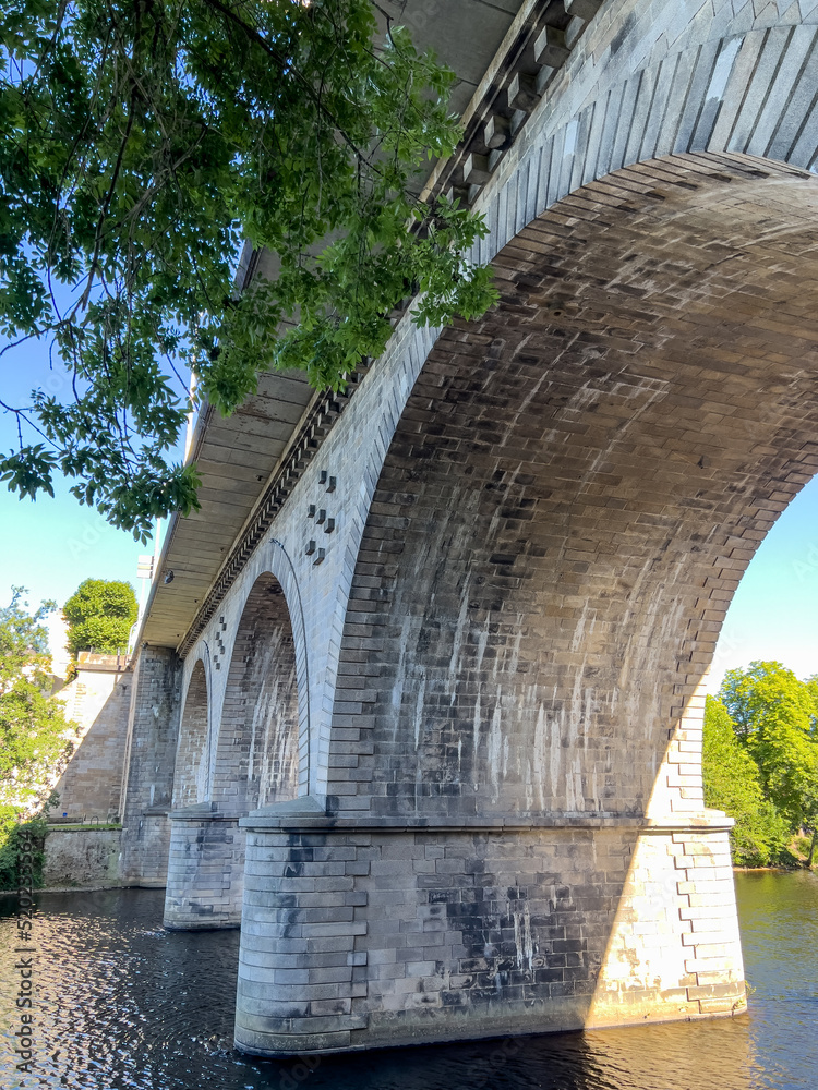 tall arched bridge over the Etienne river in Limoges, France with blue ...
