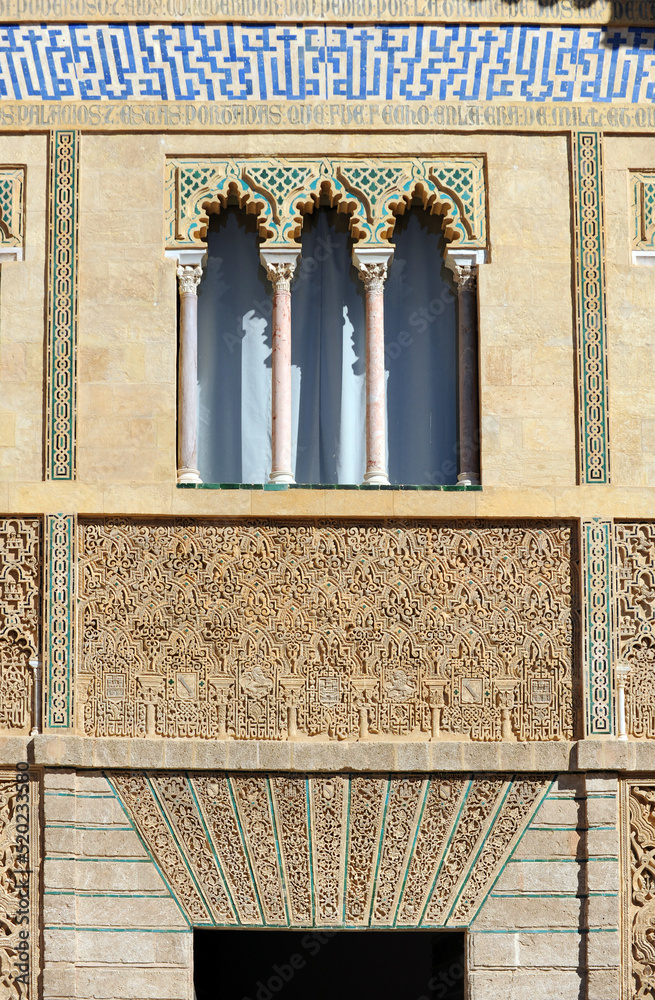 Window with polylobed and tiled arches. Reliefs on the facade of the ...
