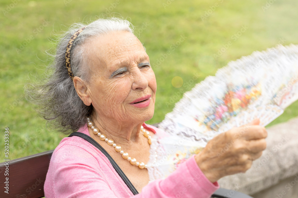 Heat wave. Elderly woman fanning herself due to high temperatures in ...