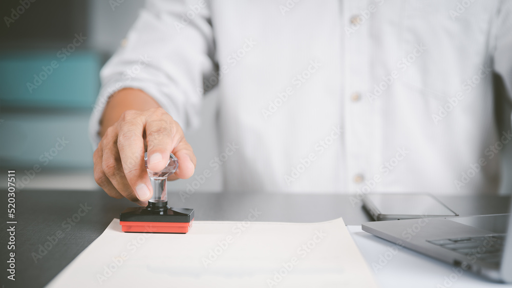 A young executive is stamping on documents for a business contract ...