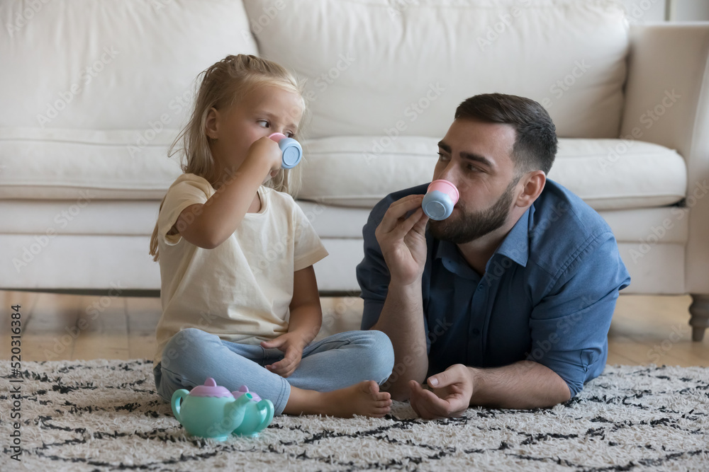 Caring dad and cute little daughter girl playing tea party, imagining ...