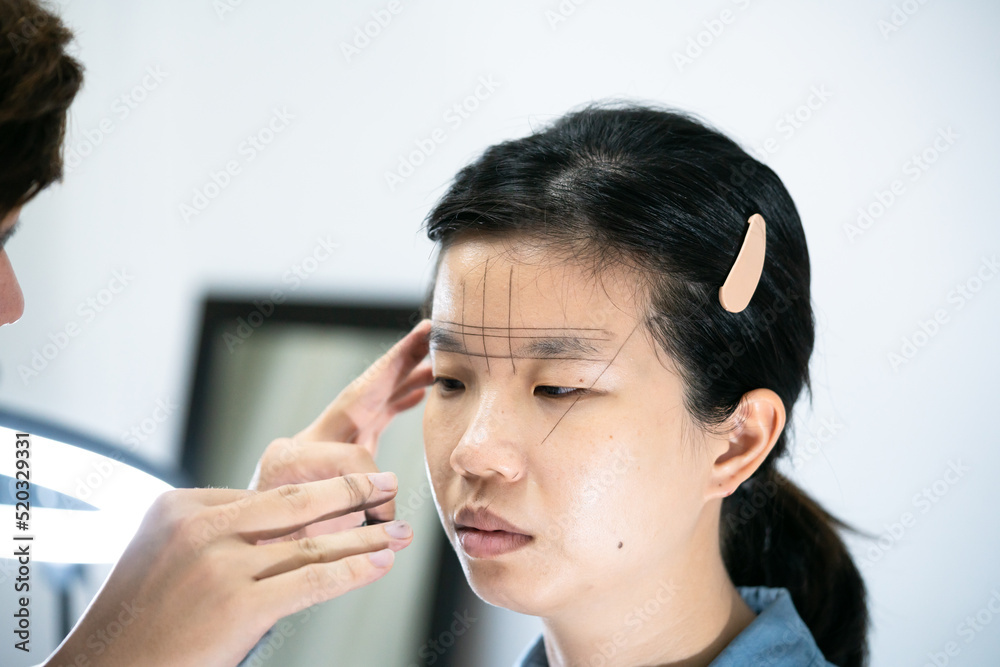 The process of shaping eyebrows by a beauty master with a thread for a ...