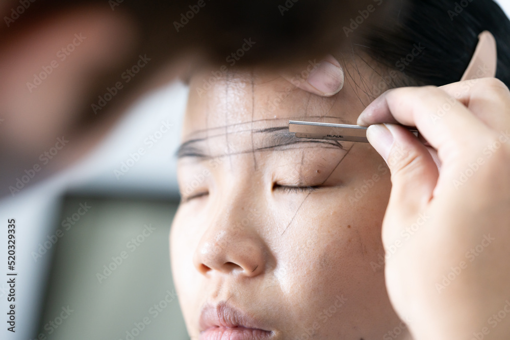 The process of shaping eyebrows by a beauty master with a thread for a ...