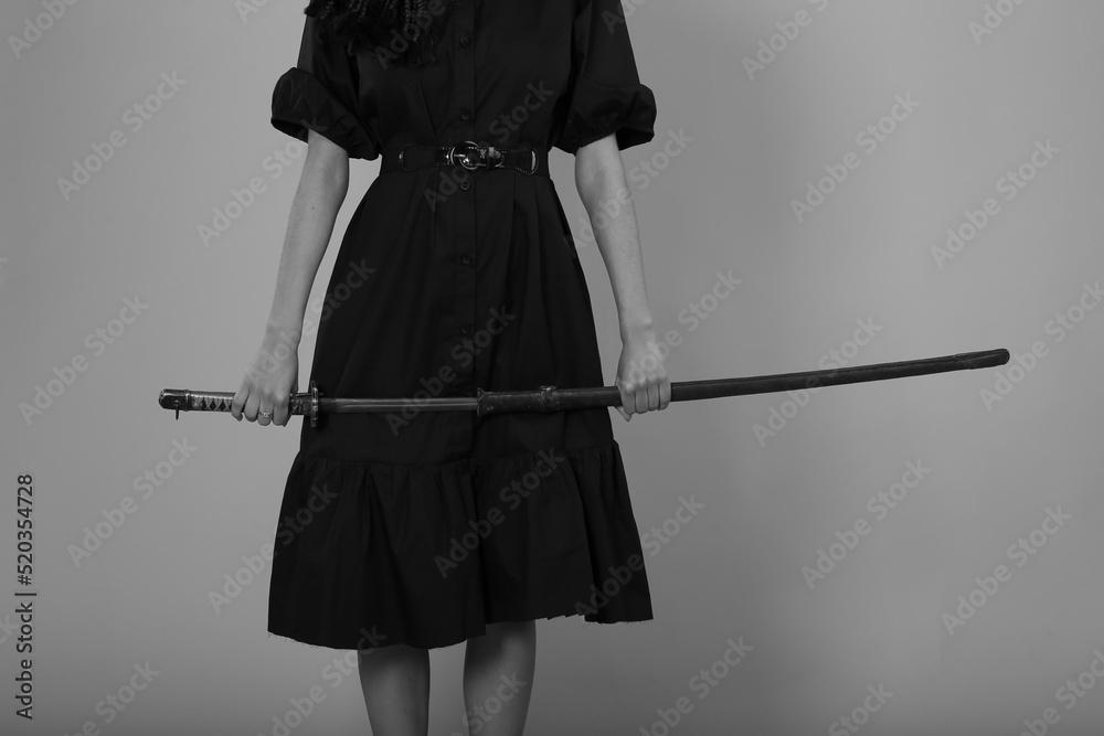 Katana sword in female hands on a background of a silhouette without ...