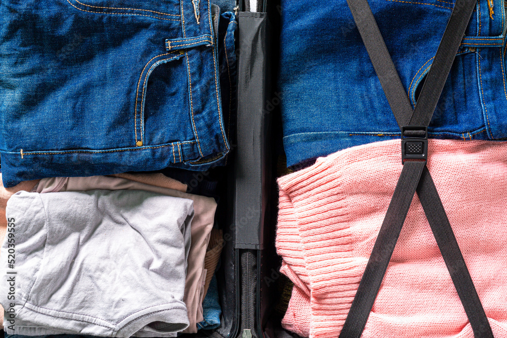 Jeans and clothes in luggage,jeans in suitcase top view,Packing ...