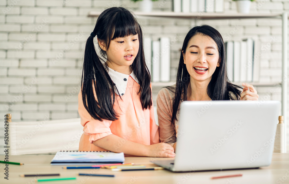 Mother and asian kid little girl learn and look at laptop computer ...