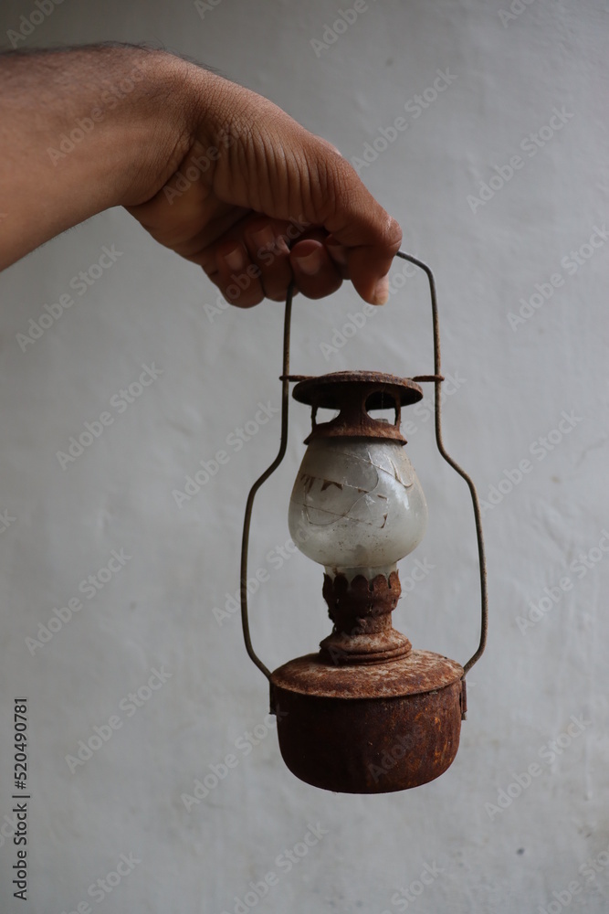 A traditional 19th century hand-held kerosene lantern, made of steel ...