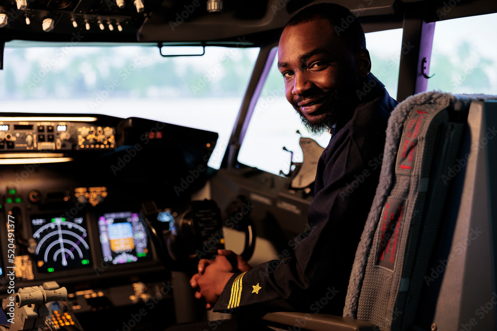 Portrait of happy airliner sitting in airplane cockpit ready to fly ...