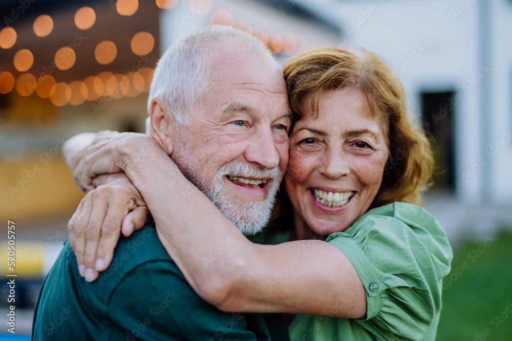 Senior woman nad man dancing and hugging together in a garden in summer ...