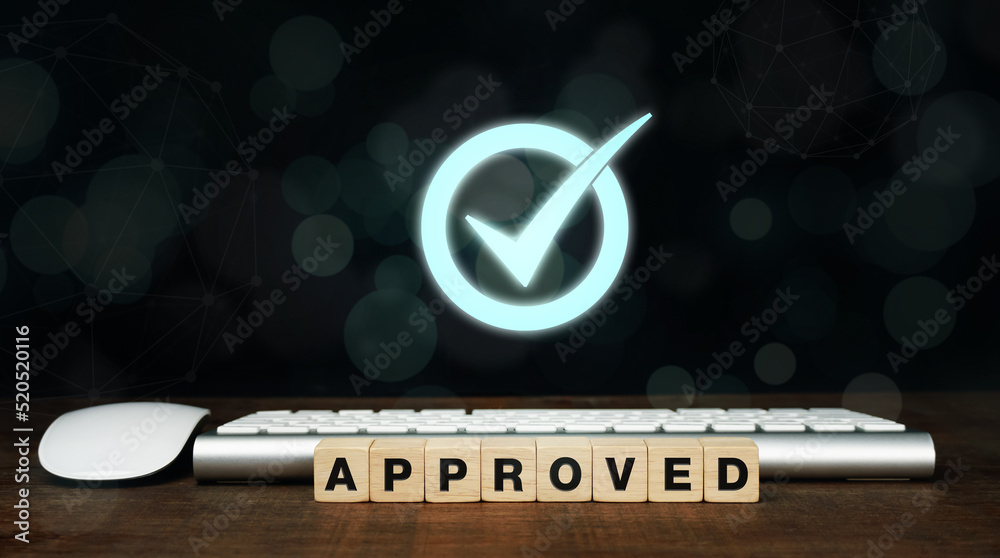 Cube with words approved on keyboard background with graphics. check ...