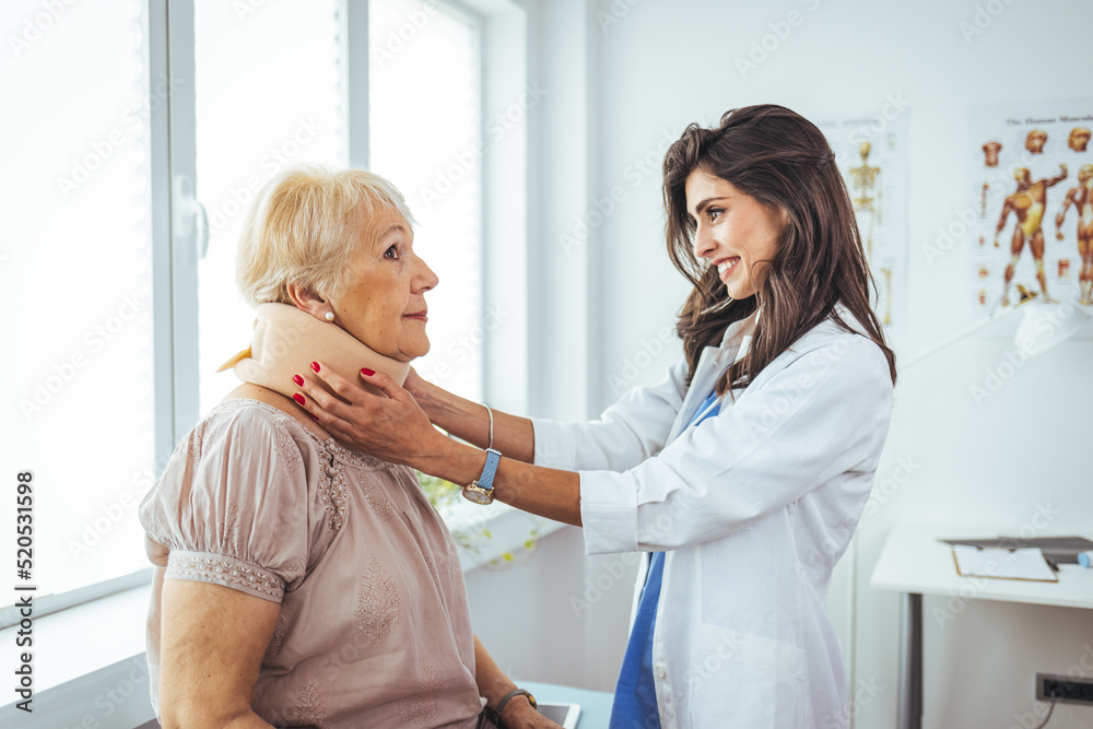 Female doctor putting neck orthopaedic collar on adult injured woman ...