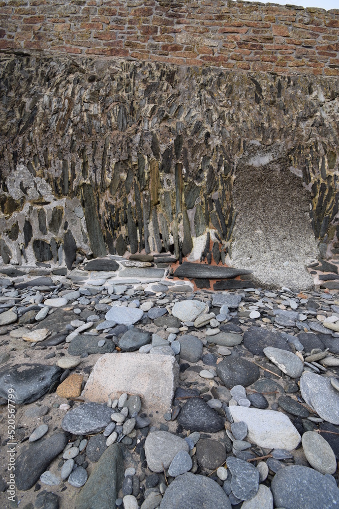 Varied mix of colors, textures and types of wet rock on the stone beach ...