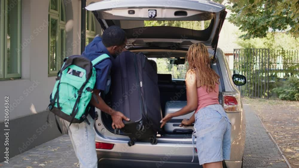 People putting baggage and trolleys inside car while getting ready for ...