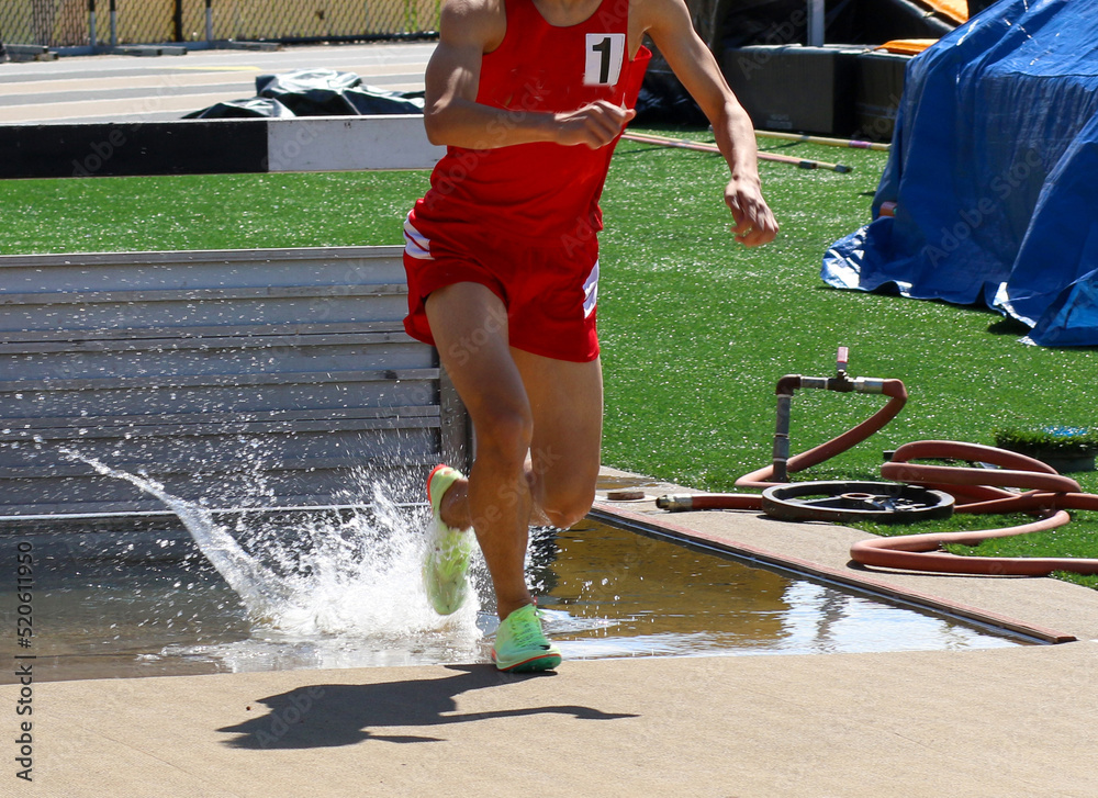 Runner with a number one on his uniform splashing as he exits the ...