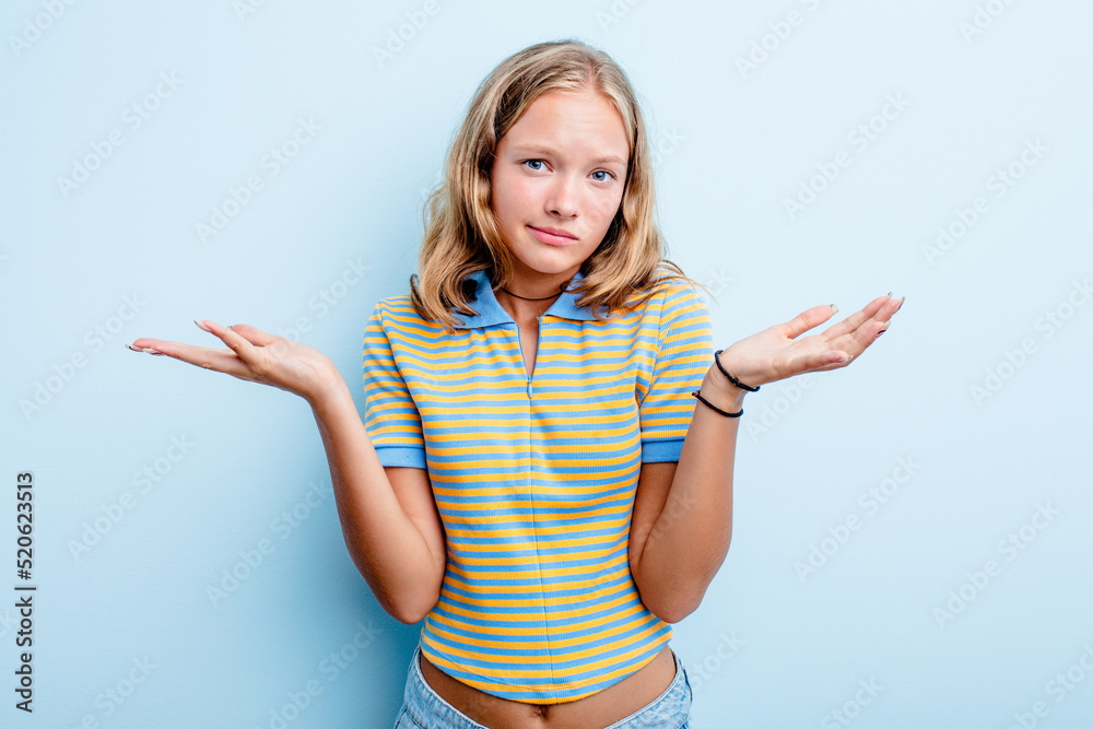 Caucasian teen girl isolated on blue background doubting and shrugging ...