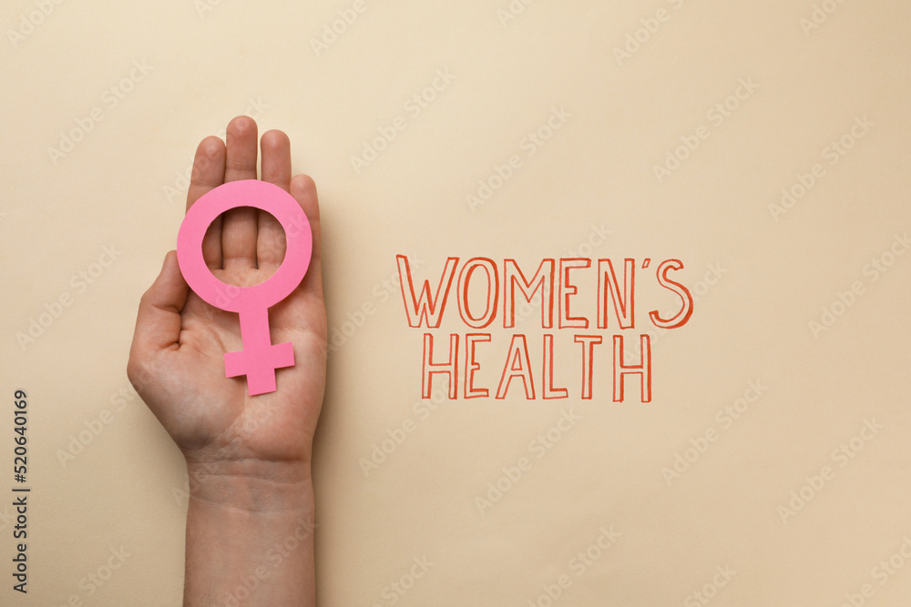 Girl holding female gender sign near text Women's Health on beige ...