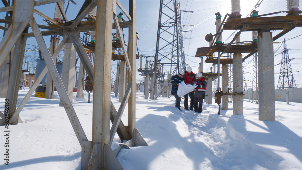 Engineers at electrical substation in winter. Action. Engineers and ...