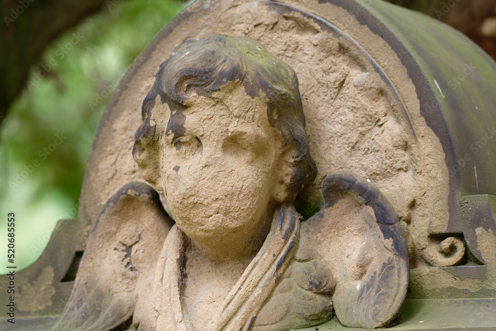 creepy ancient angel figure with weathered face in a cemetery in ...