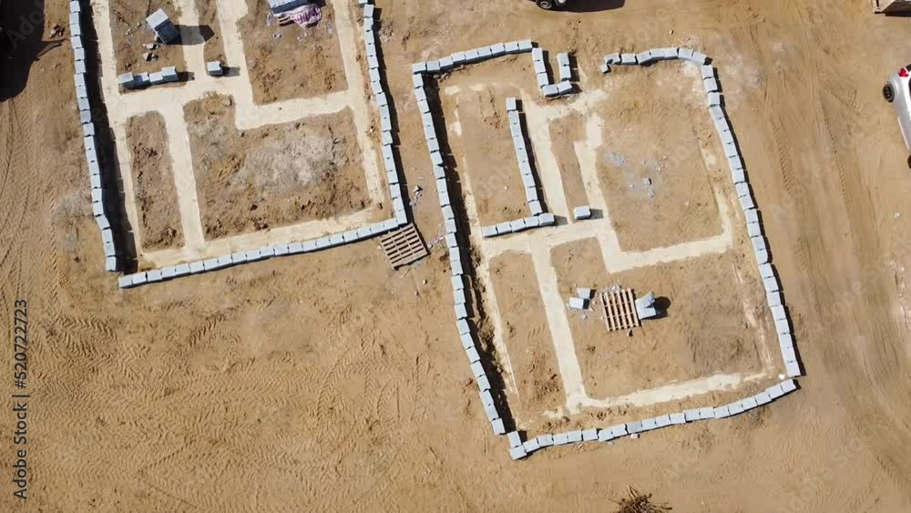 Ascending rotating aerial view of the marked out housing foundations on ...