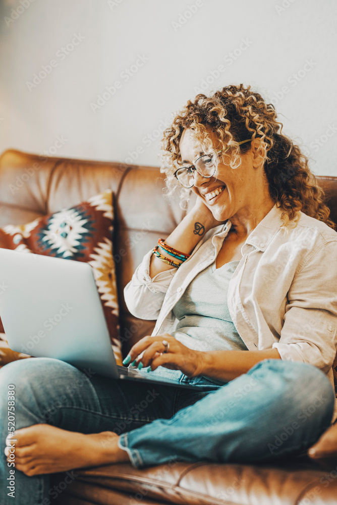 Happy woman using laptop at home to video call friends or parents ...