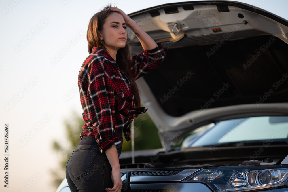Car breakdown on road. Young desperate woman desperately trying to fix ...