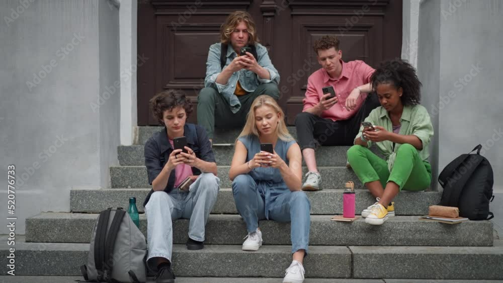 Group of teenagers sitting in outdoor stairs in front of school ...