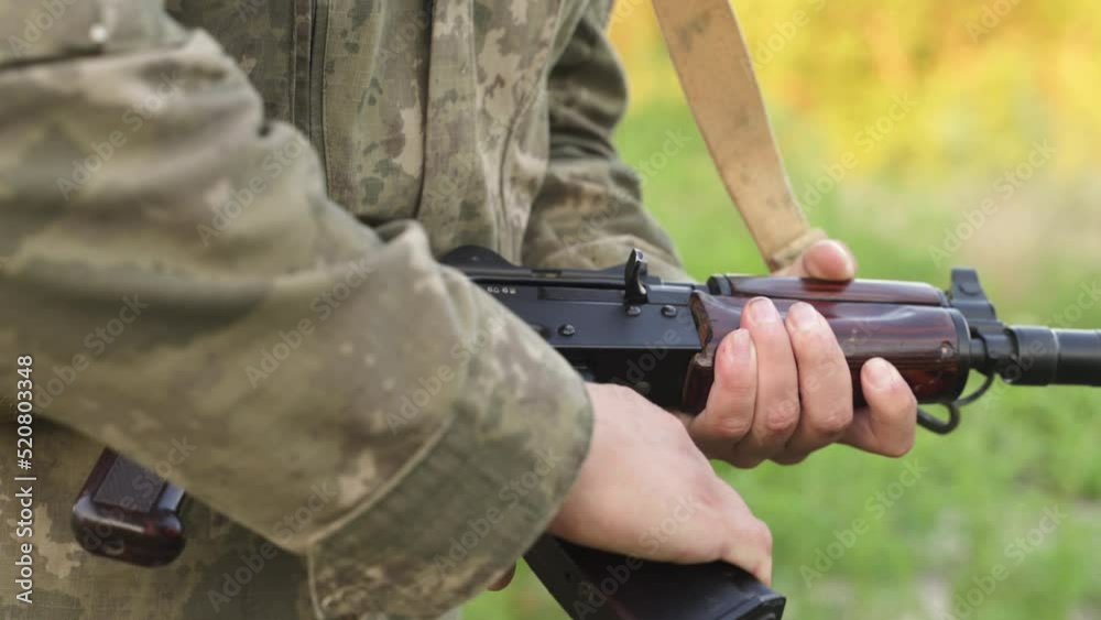 a Ukrainian soldier in camouflage holds a machine gun in a combat position. an infantryman at a ...