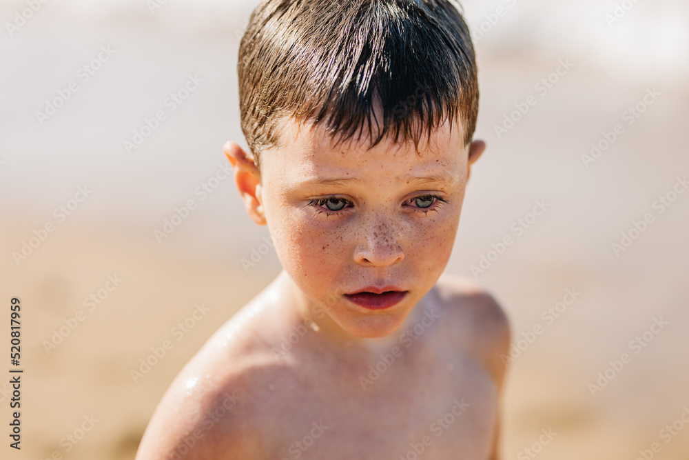 Sad boy standing on beach in summer Stock Photo | Adobe Stock