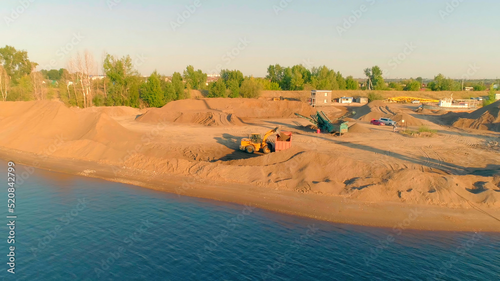 Excavator and heavy transport cleans beach. Scene. Clearing or ...