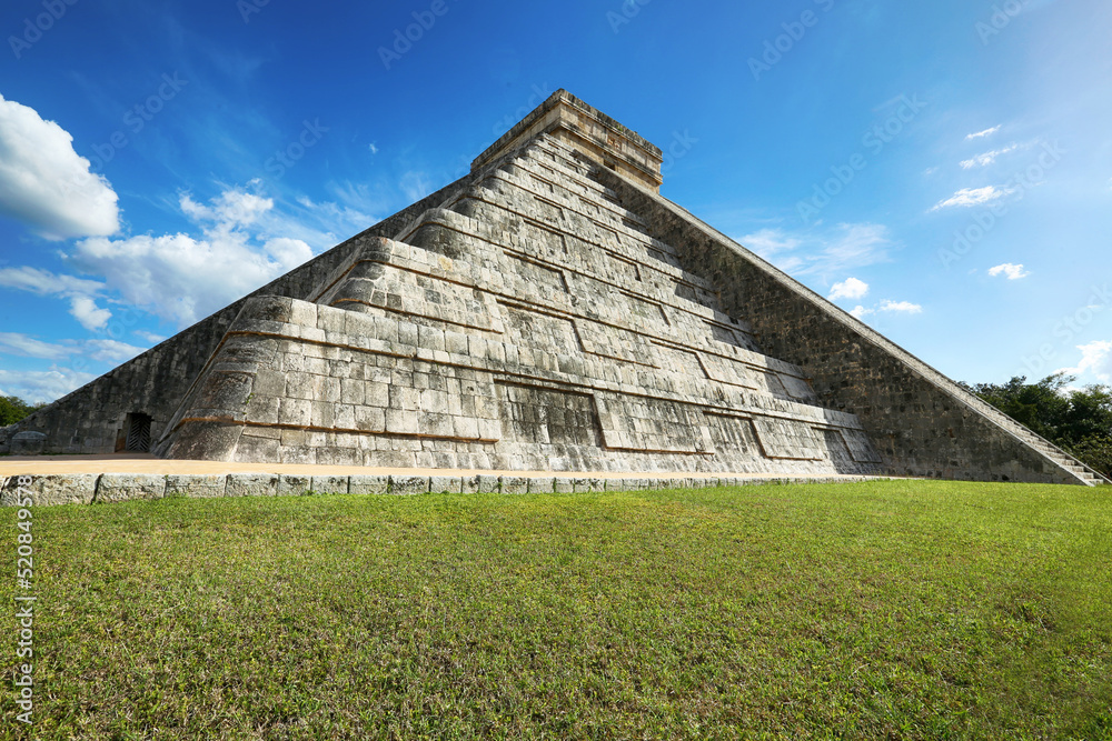 Kukulcan Mayan pyramid "El Castillo" with the sun rising from behind ...