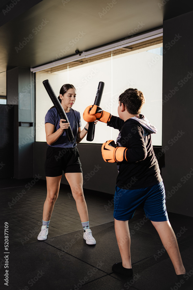 female boxing coach training a boy in gym (boy punching) Stock Photo ...
