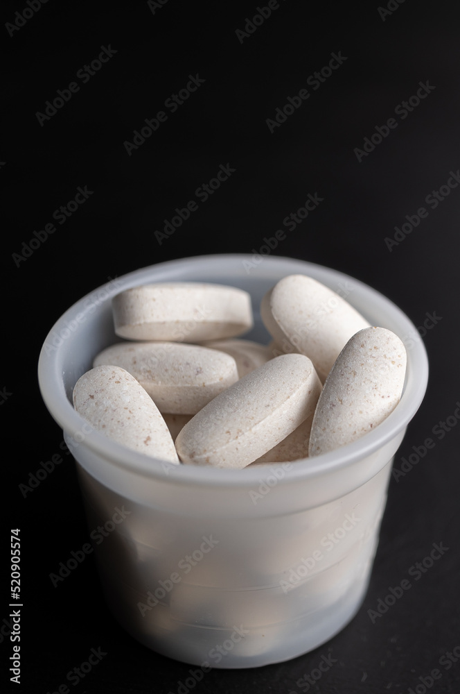 bote de plástico lleno de comprimidos o pastillas de calcio y colágeno ...