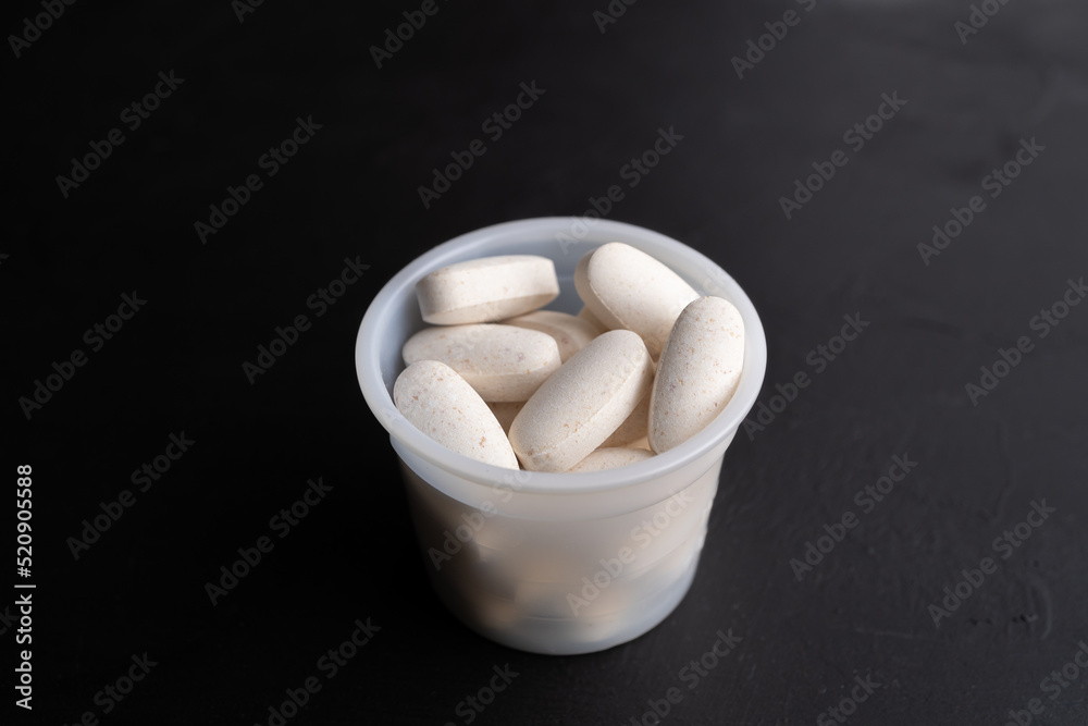bote de plástico lleno de comprimidos o pastillas de calcio y colágeno ...
