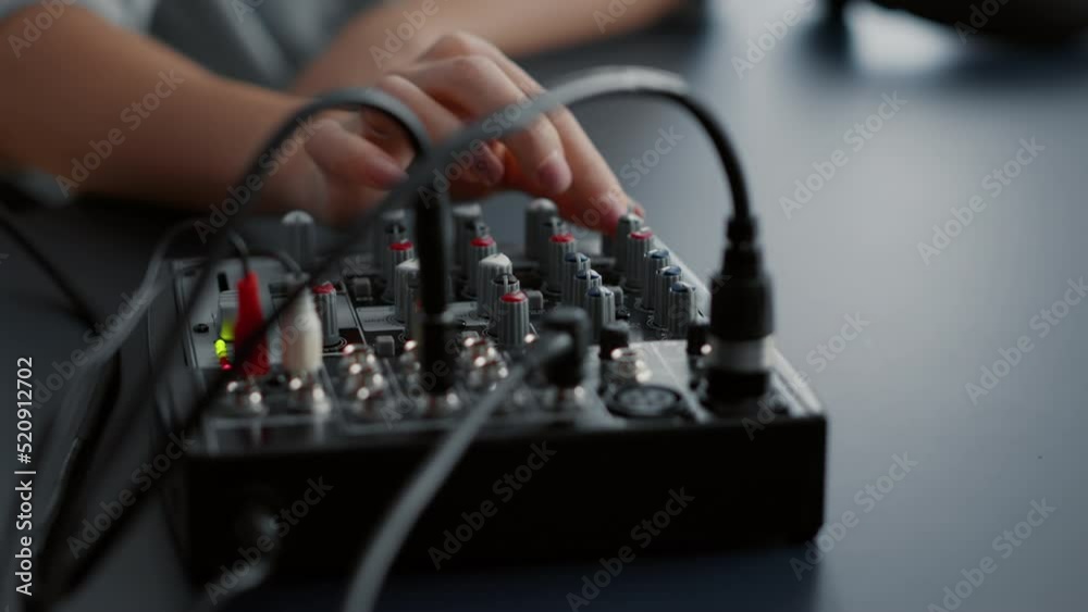 Woman tweaking audio mixer knobs and buttons. Internet radio host ...