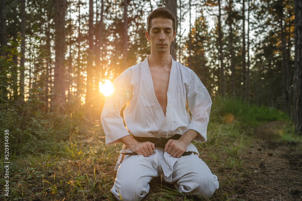 One man caucasian karateka meditate during karate training practice in ...